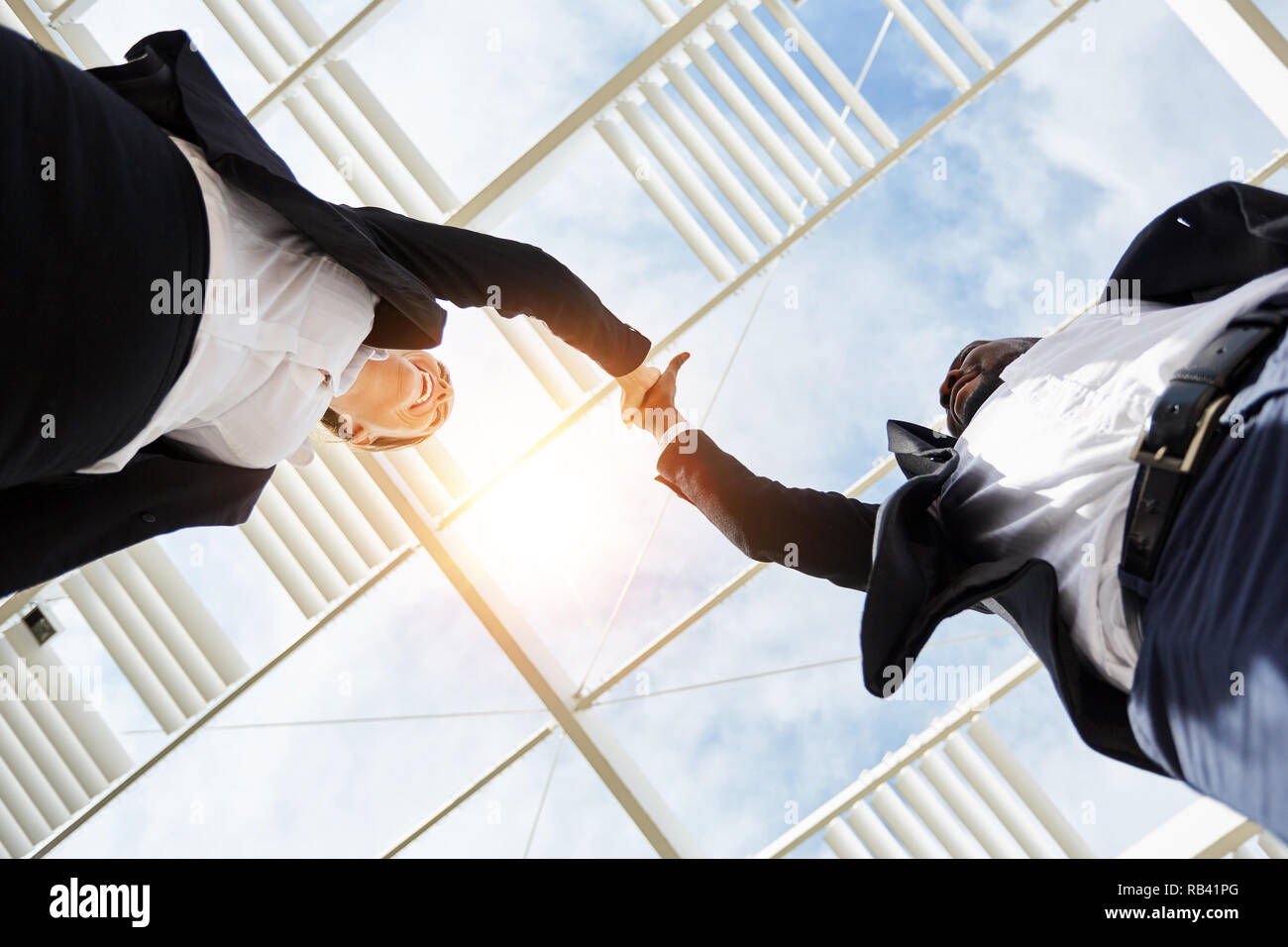Two business people give each other high five in front of the office ...