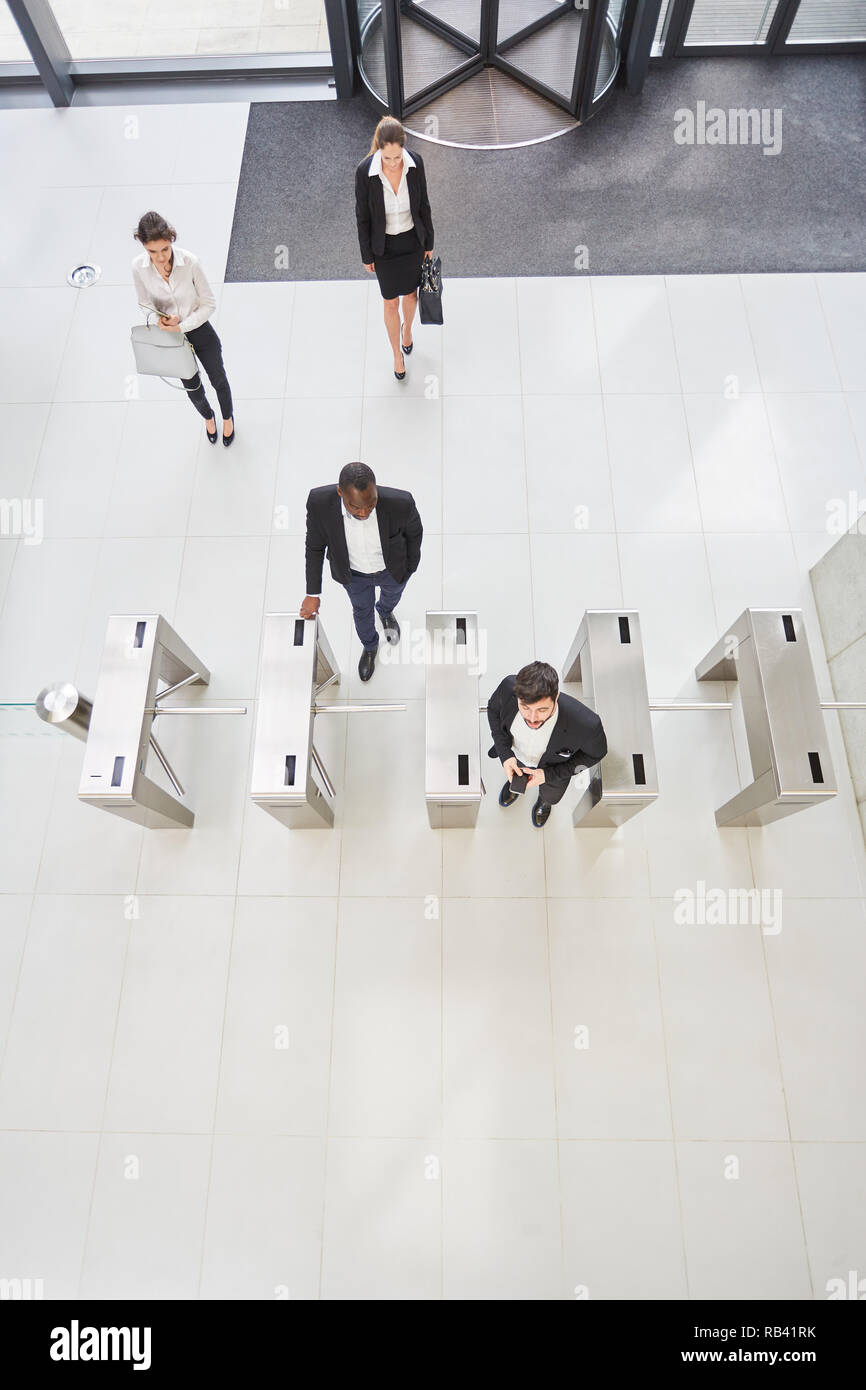 Employees in modern office building pass through turnstile as access ...