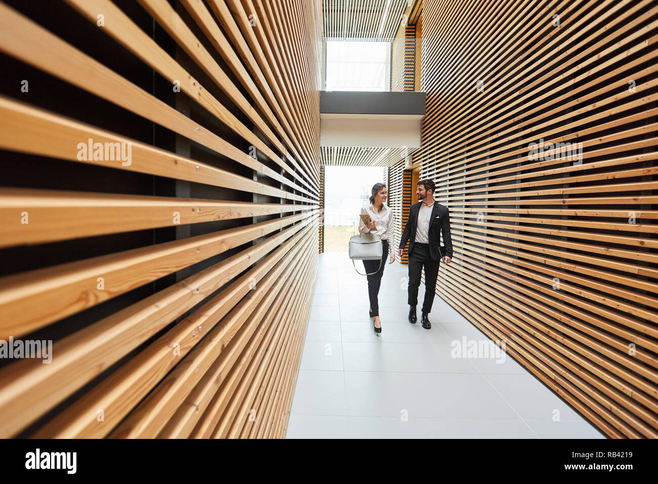 Two business people talking in the modern office building in the ...