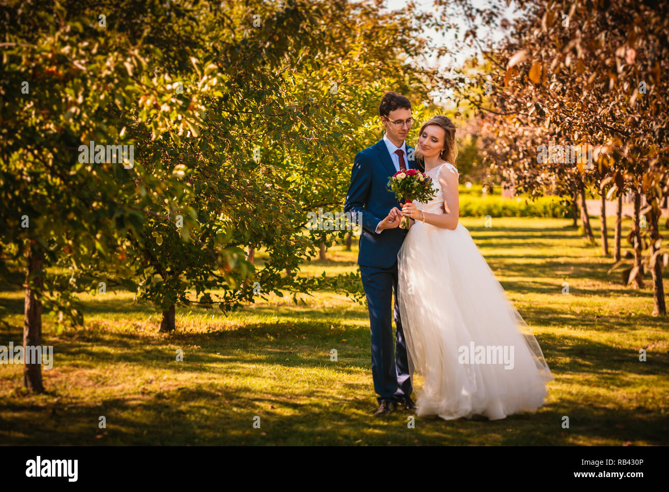 Beautiful stylish bride and groom on garden background Stock Photo - Alamy