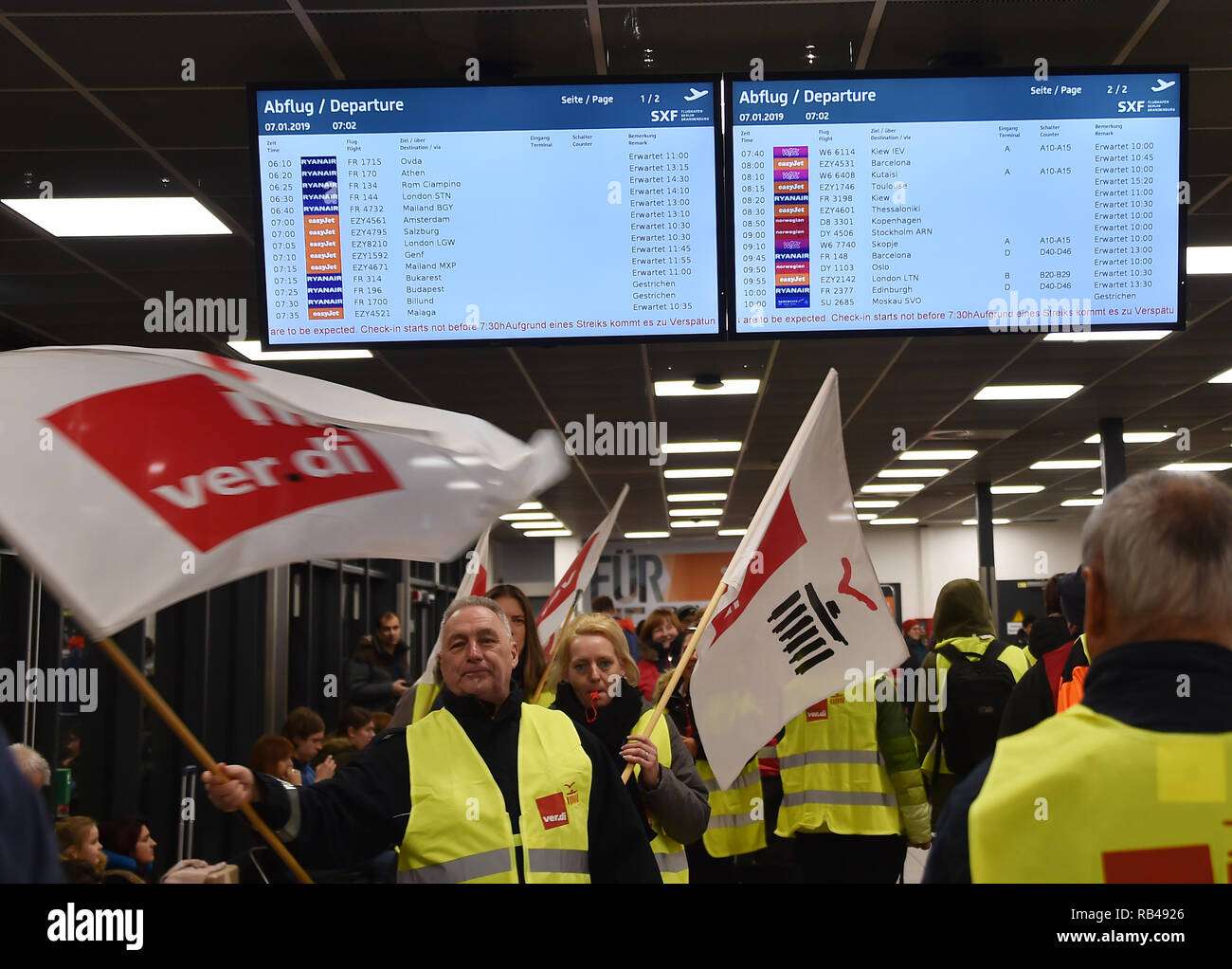 Schönefeld, Germany. 7th Jan 2019. Striking security personnel walk ...