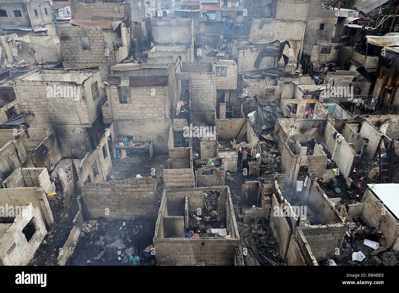 Beijing, Philippines. 6th Jan, 2019. Residents return to their charred ...