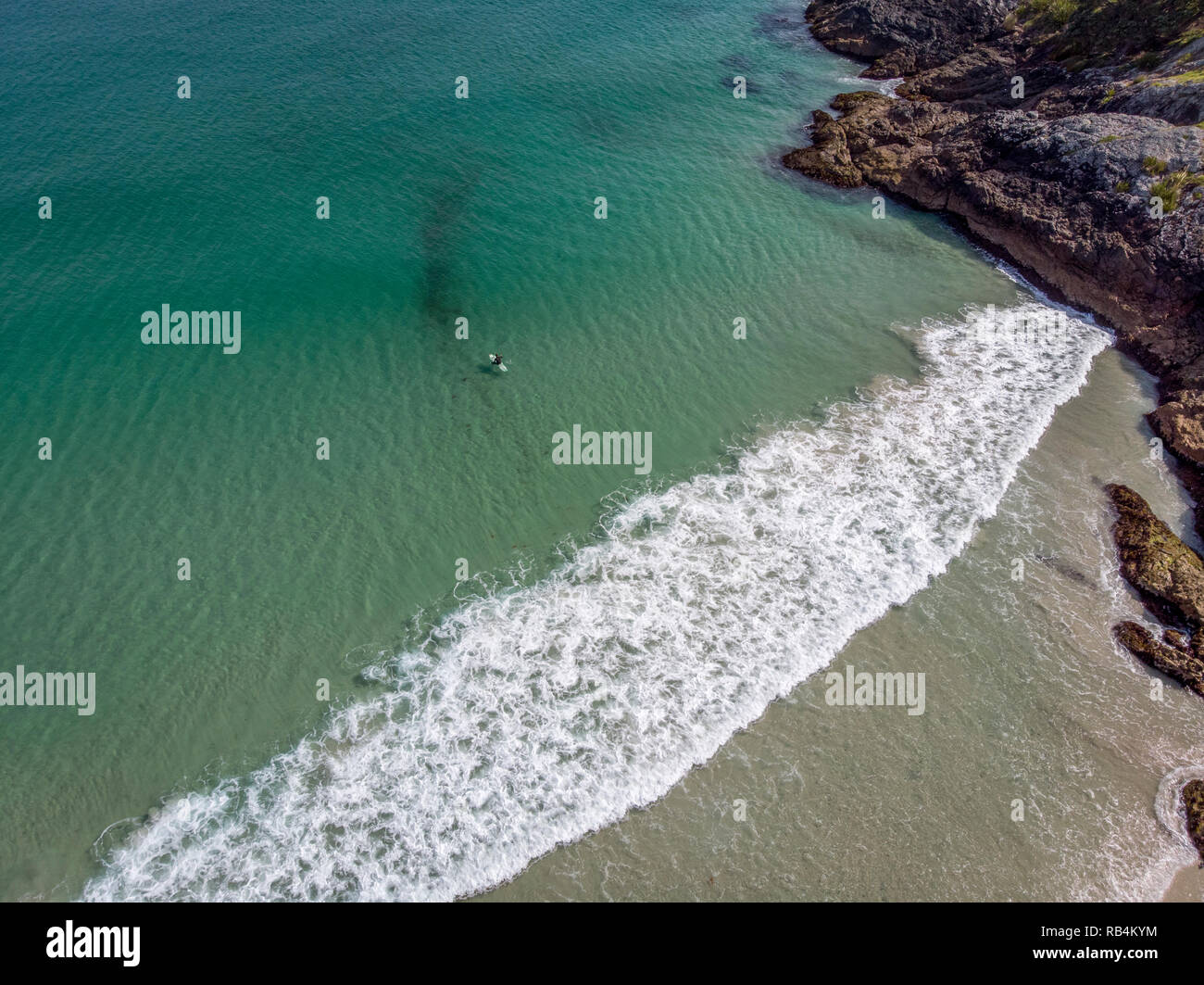 A beautiful drone photo of a surfer waiting for a wave at Puheke beach ...