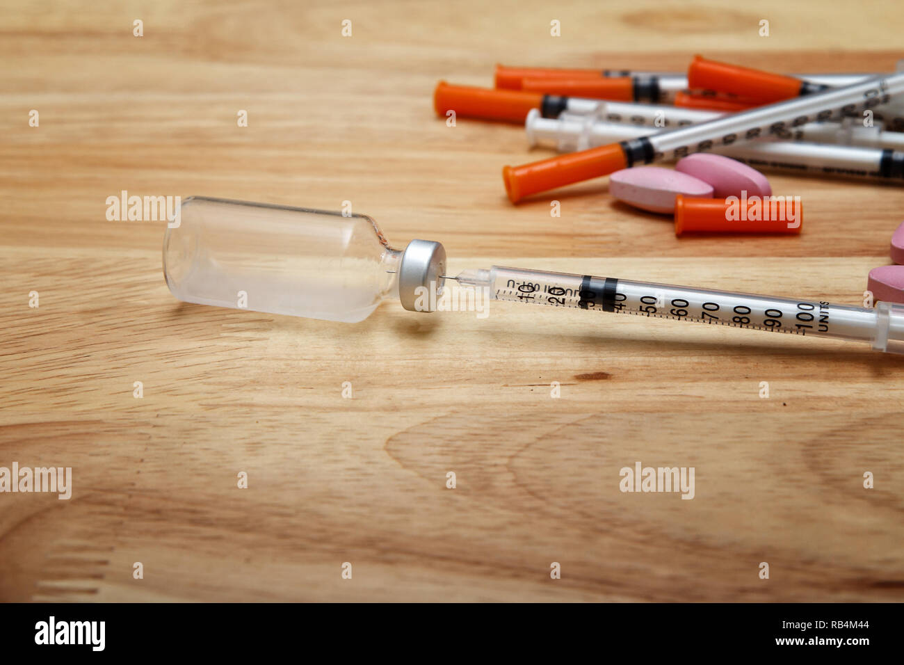 Medical syringe and bottle of potion on wooden desk Stock Photo - Alamy