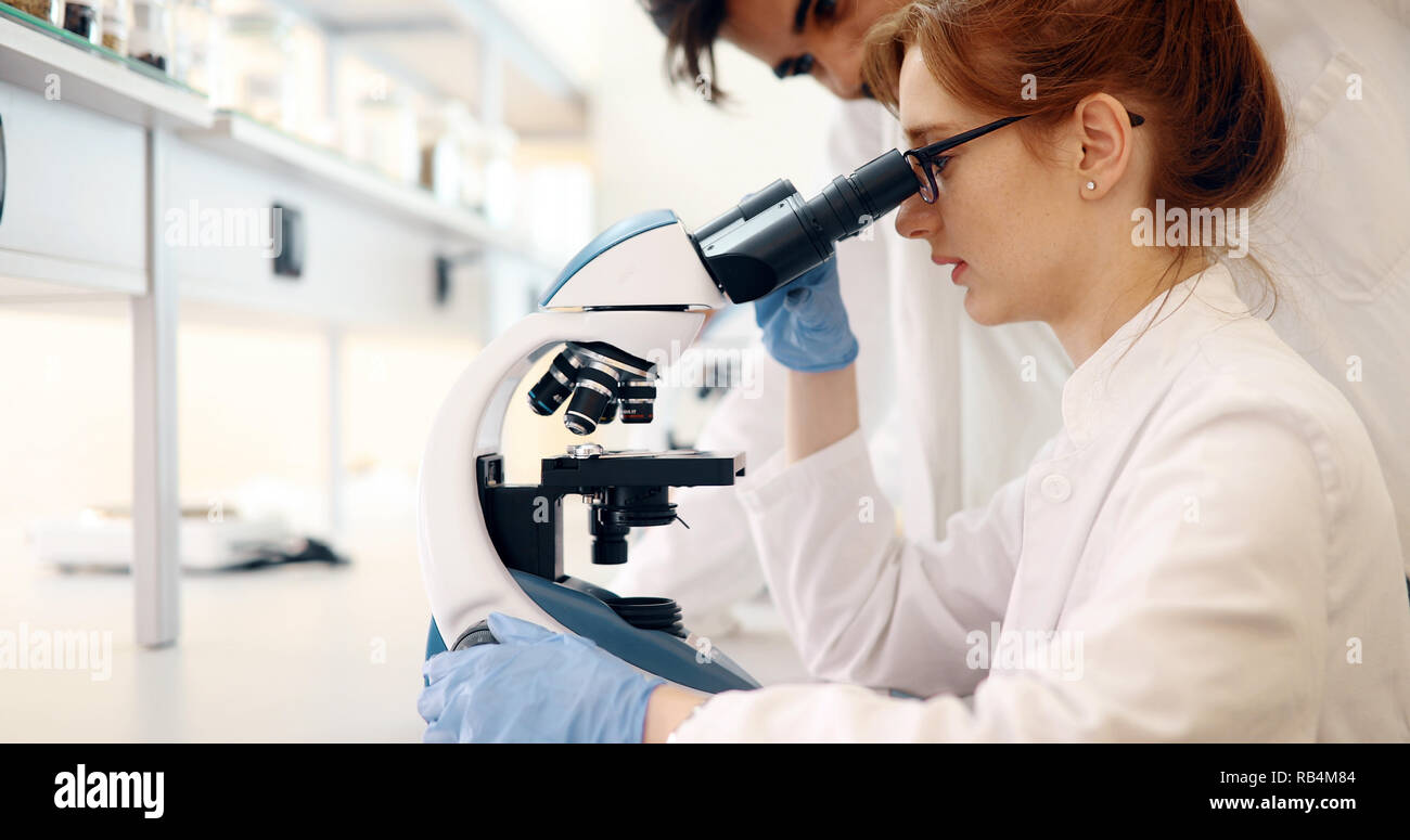 Young scientist looking through microscope in laboratory Stock Photo - Alamy