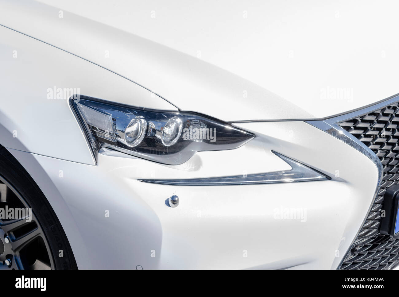 Headlight of a modern white sport car. The front lights of the car ...