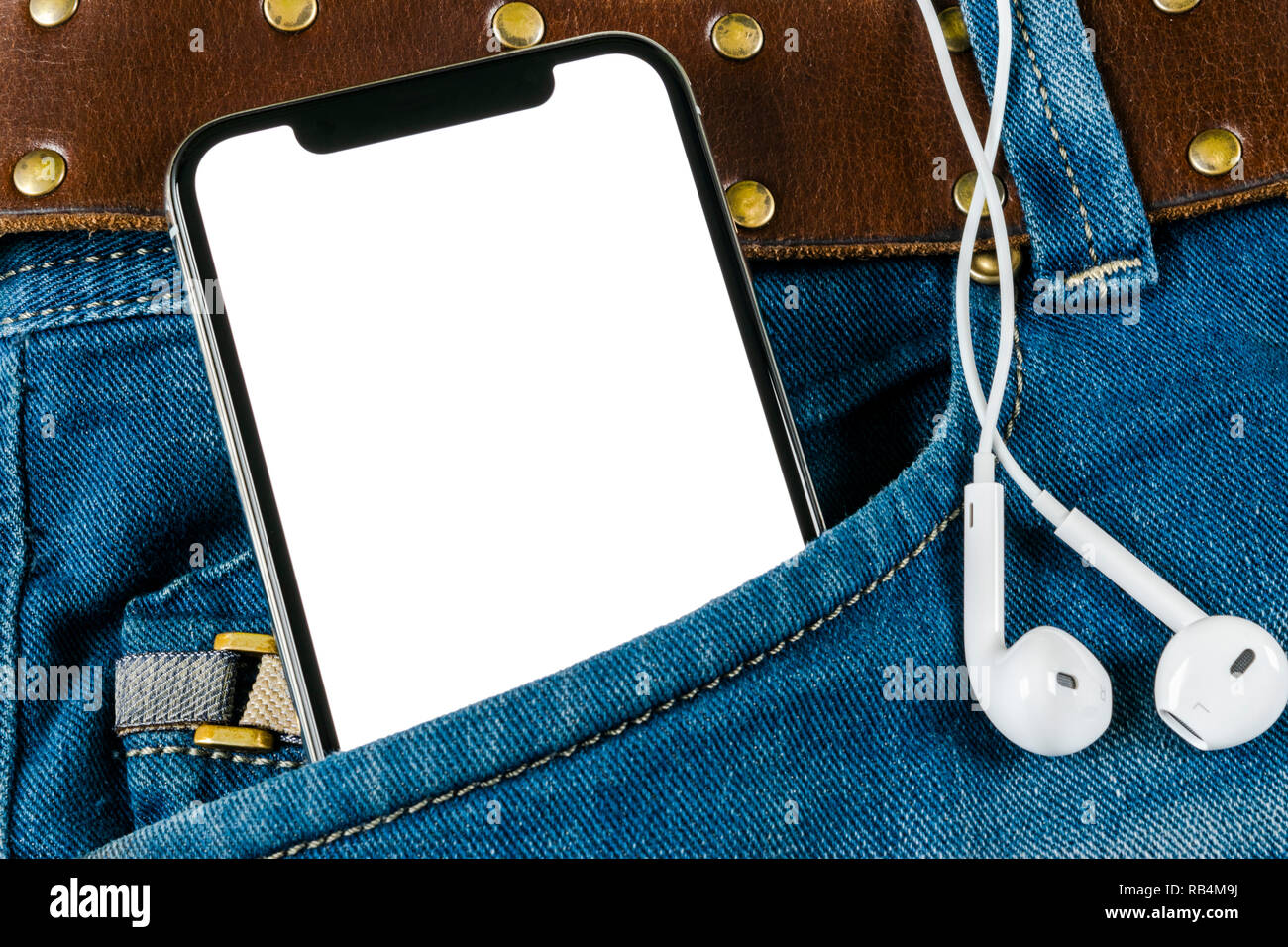 Smartphone with isolated white screen in jeans pocket with earphones ...