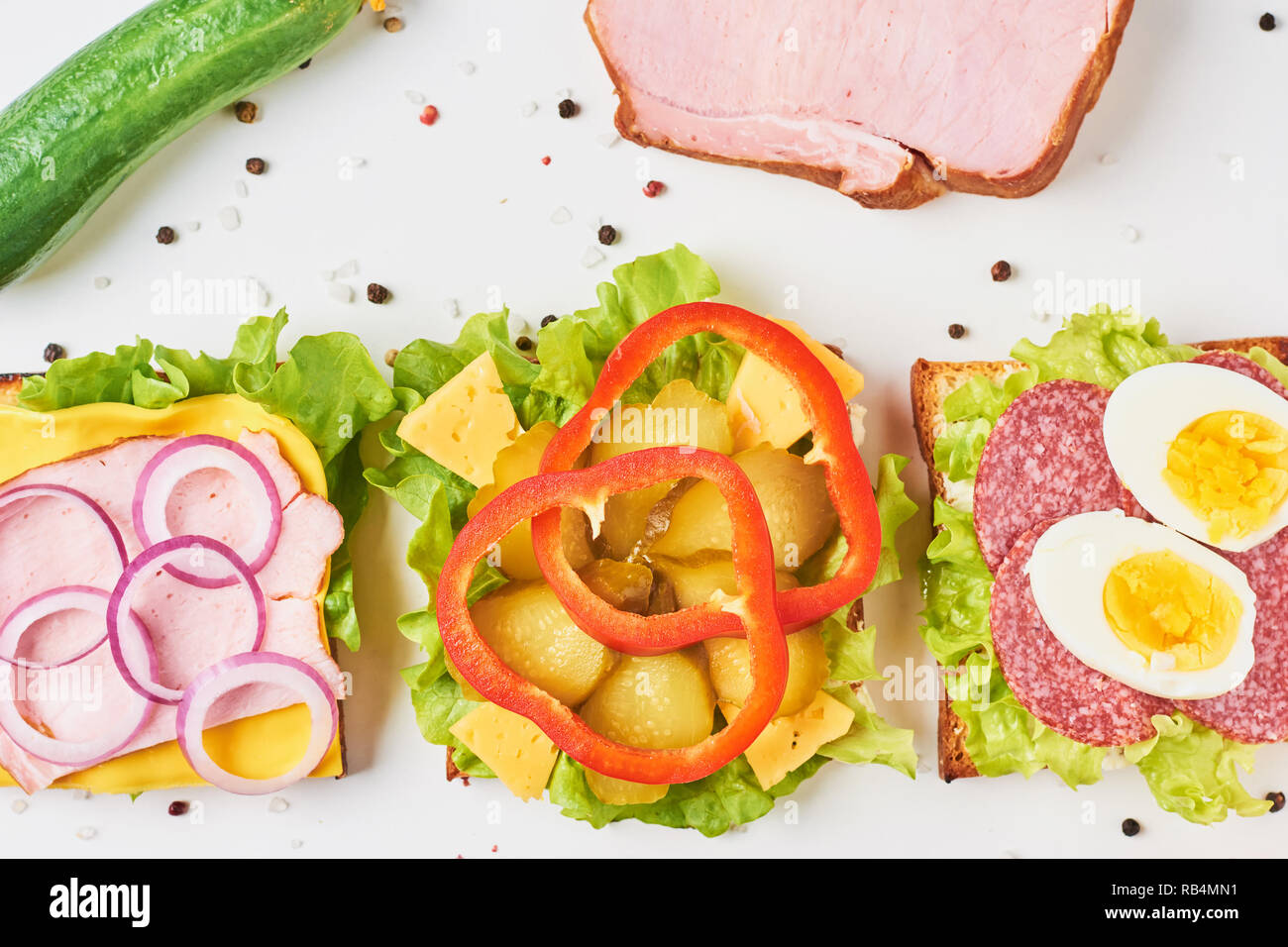 Different kind of sandwich and ingredients on white background, top ...