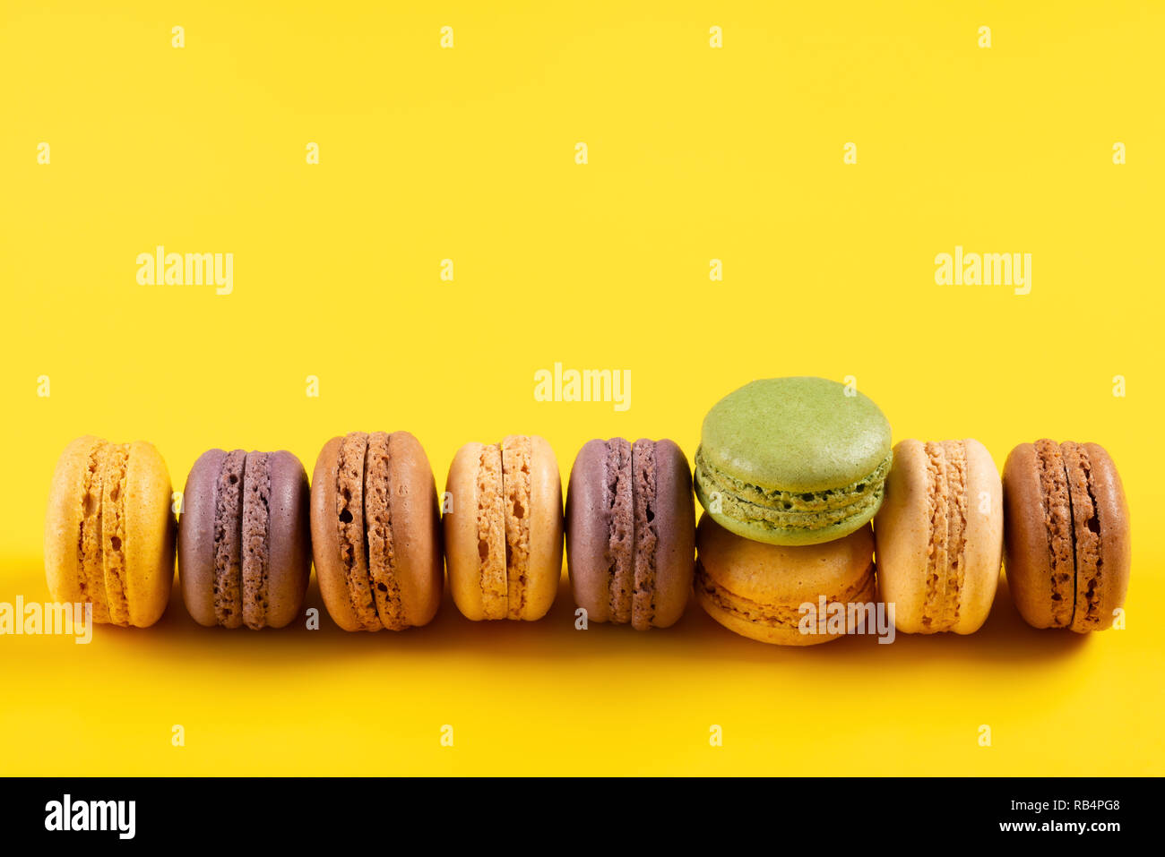 studio shoot of colorful macaroons line up on yellow background Stock ...