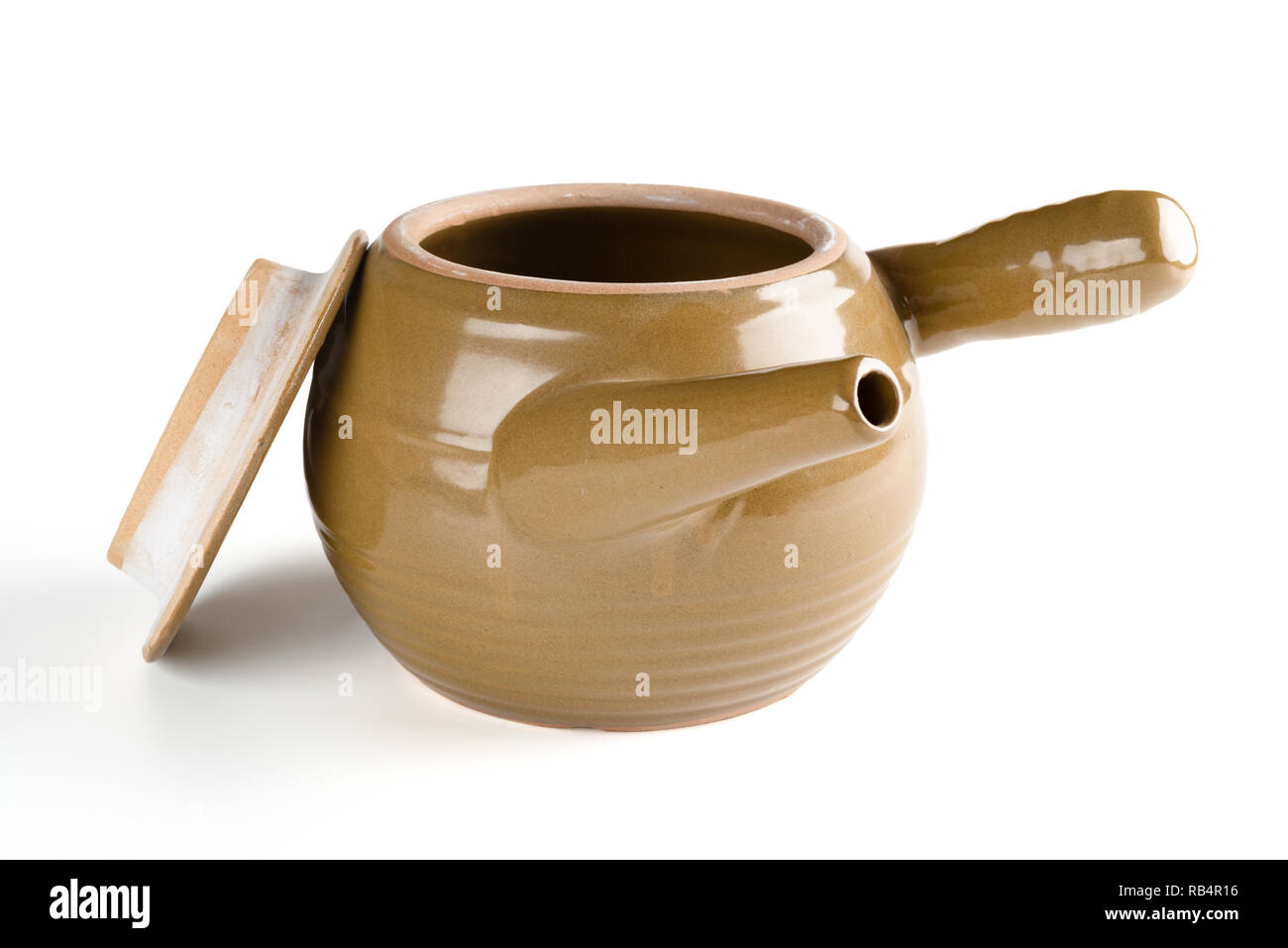 side view clay pot for boiling herb medicing with the lid open on white ...