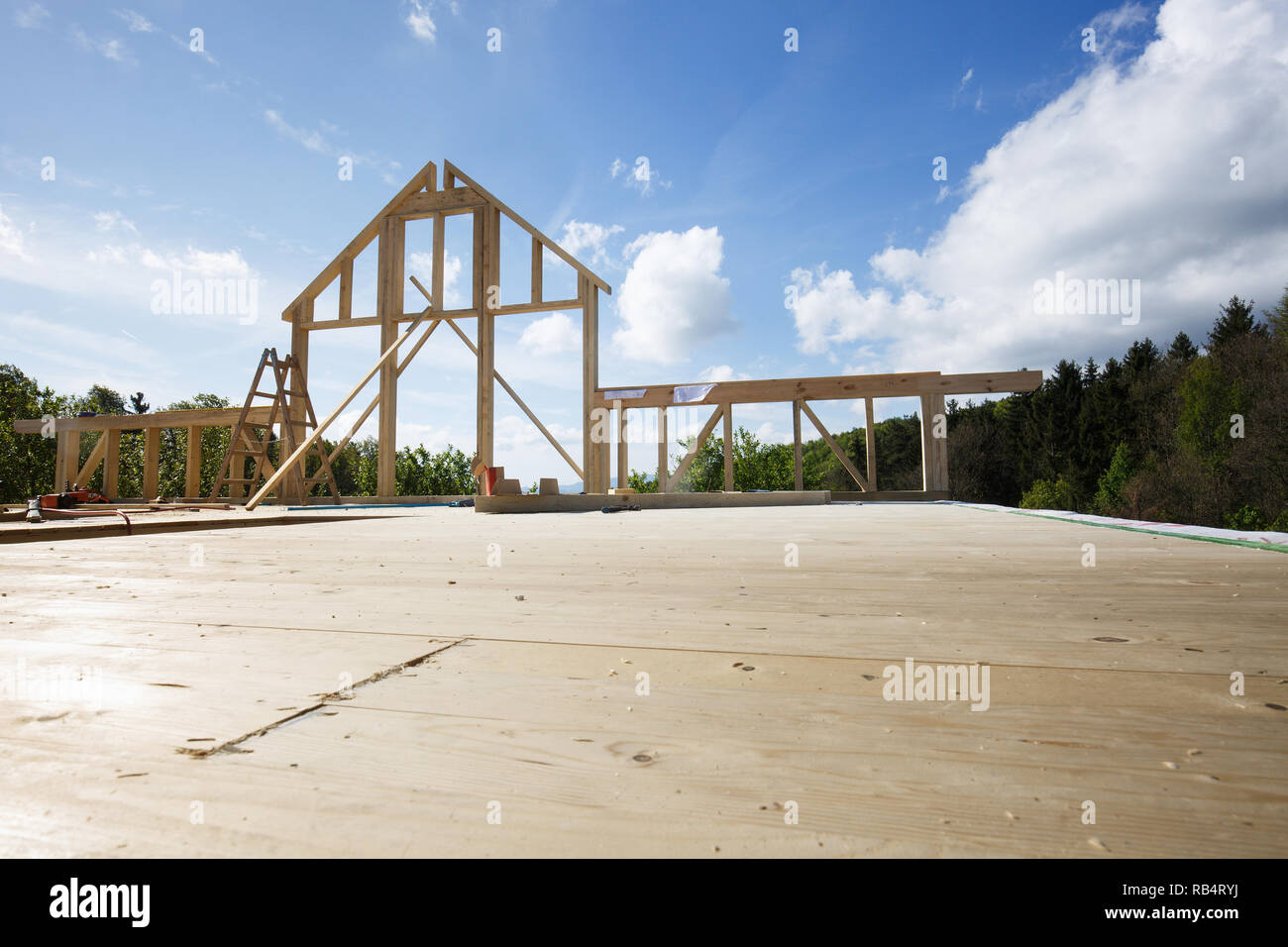 Frame of wooden house under construction, walls being erected. Building ...