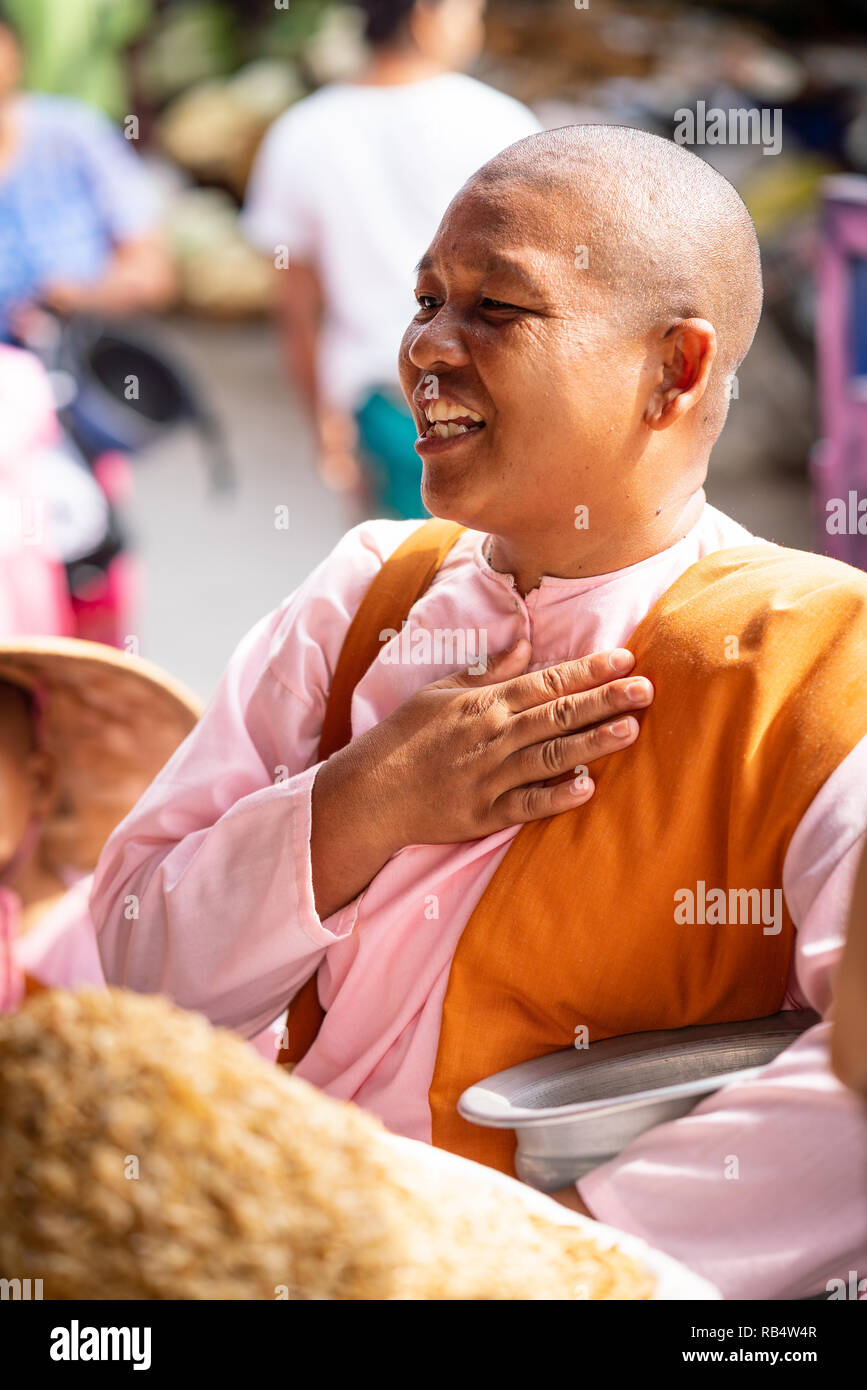 Thankful monk after receving a donatcion in a market, mandalay, myanmar ...