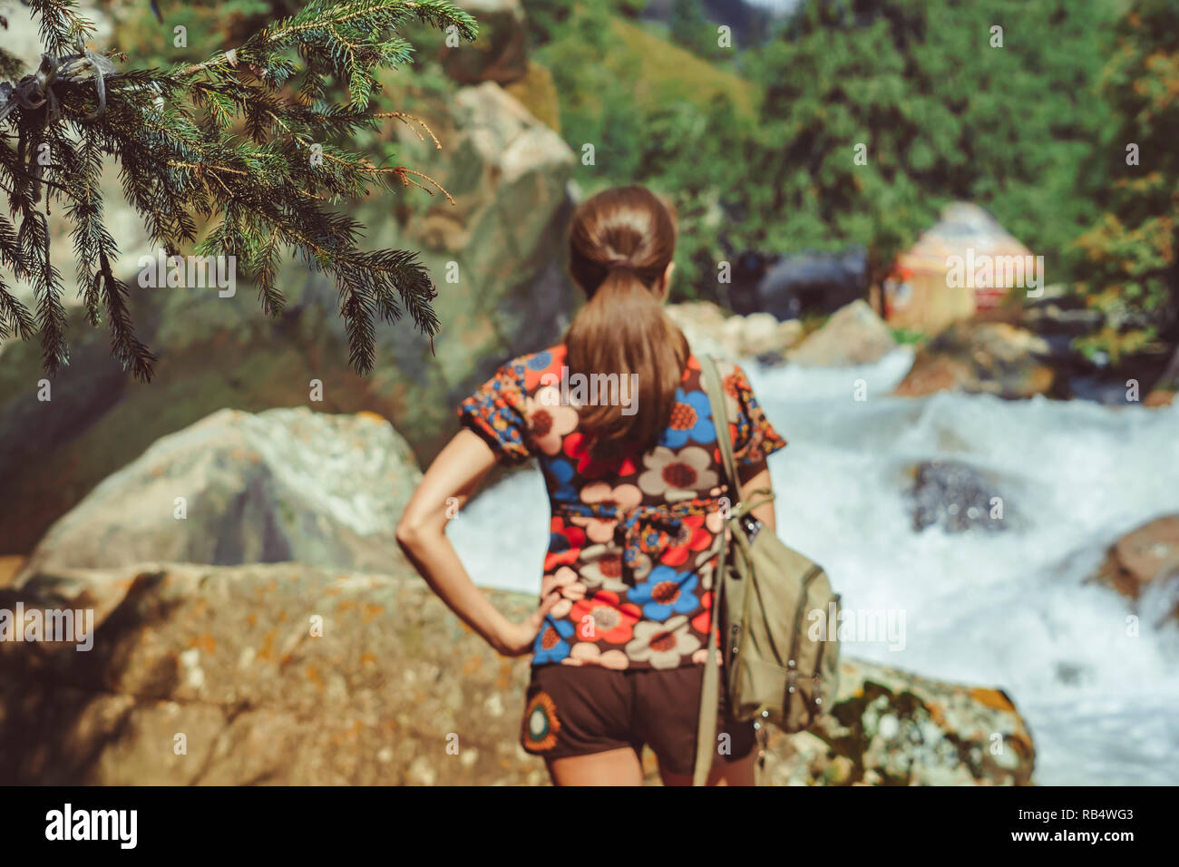 woman traveler with backpack looking at amazing mountains and river ...