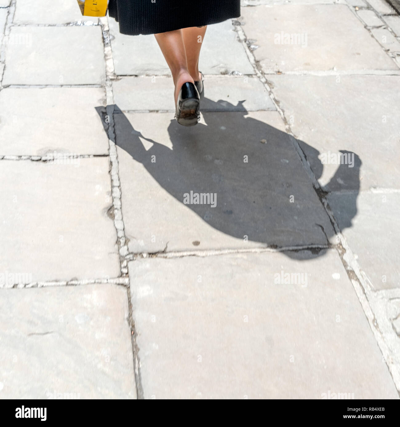 pavement with woman's legs and shadow Stock Photo - Alamy