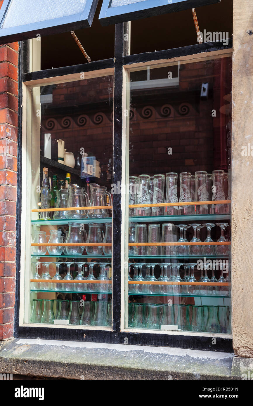 Pub window with beer and wine glasses on shelves, in Whitby, North ...