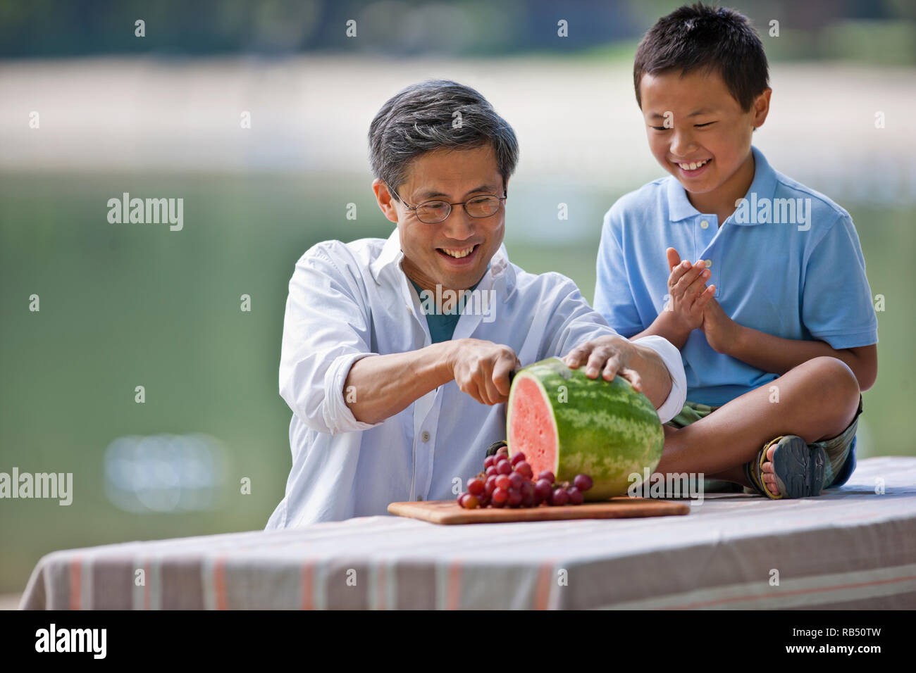 Happy father and son enjoying watermelon together Stock Photo - Alamy