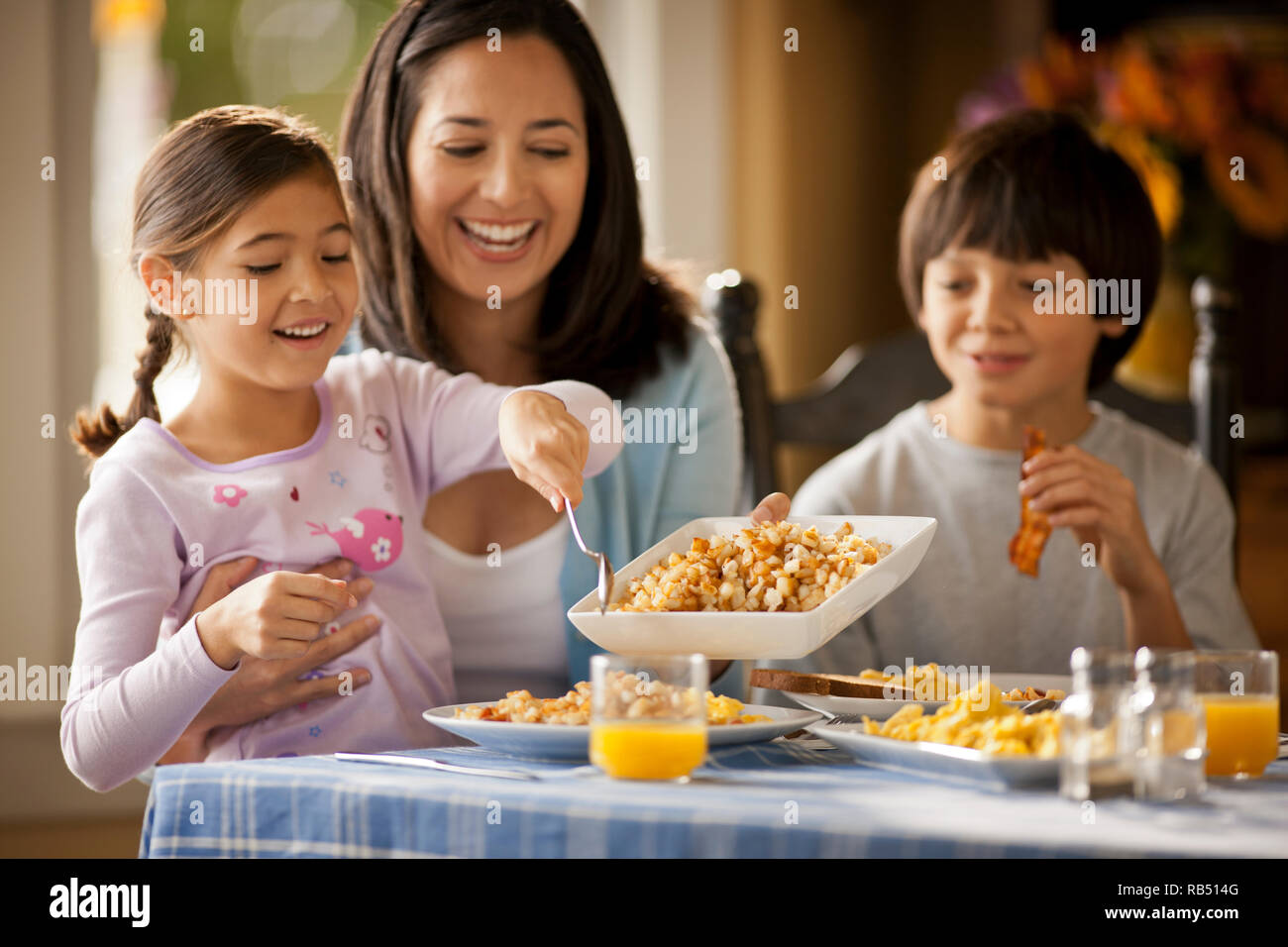 Happy family having fun eating at a dining table Stock Photo - Alamy
