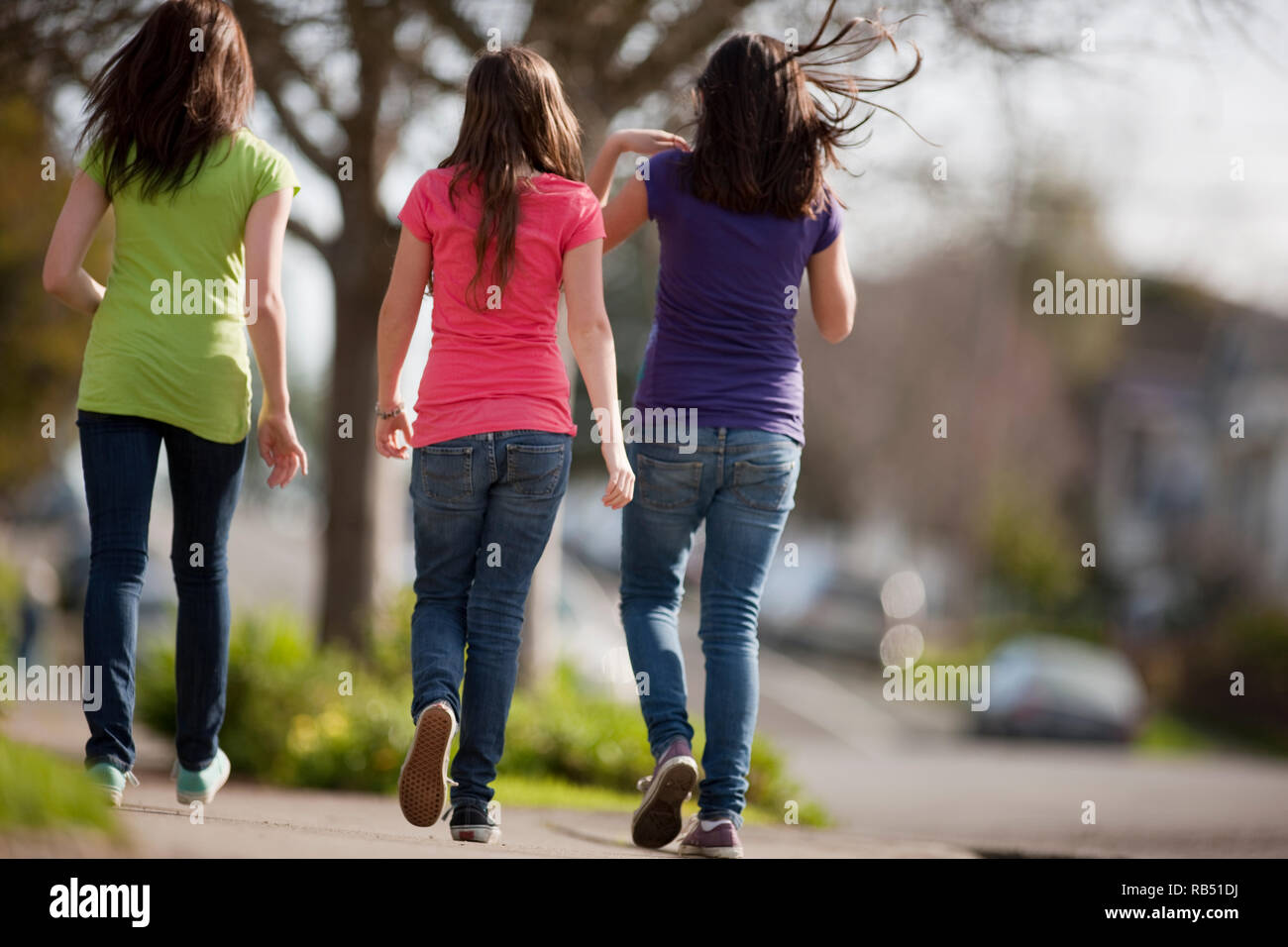 Three friends walking down the street together Stock Photo - Alamy