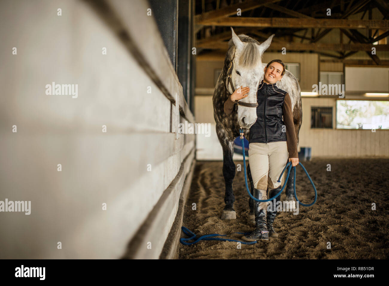Happy woman training her horse in an exercise yard Stock Photo - Alamy