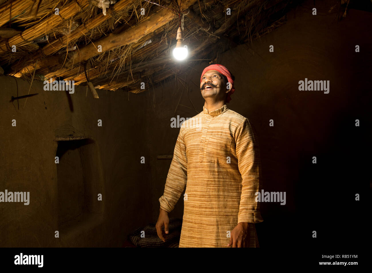 Rural Indian man delighted at the glow of light bulb and electricity ...