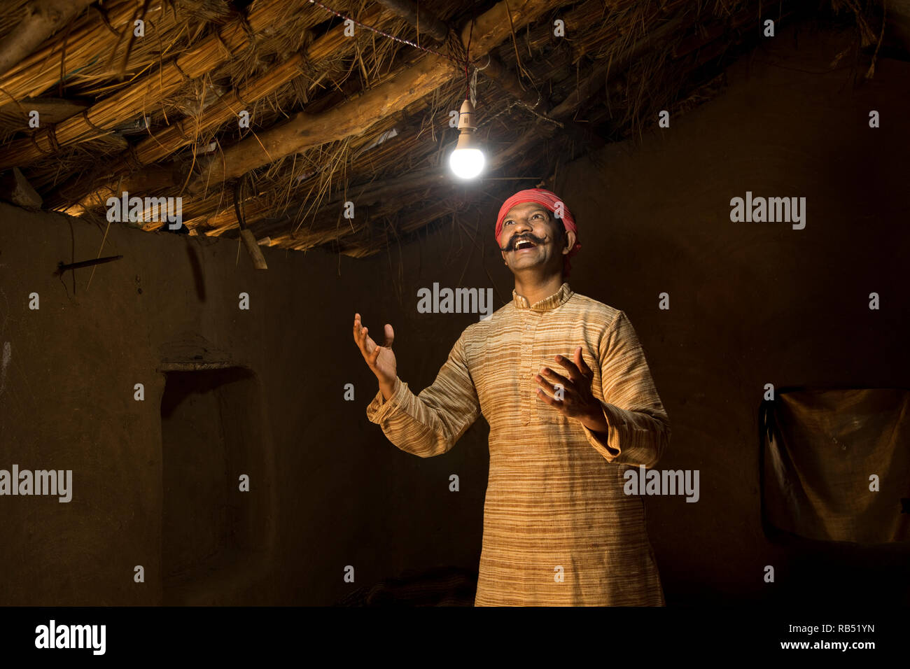 Rural Indian man delighted at the glow of light bulb and electricity ...
