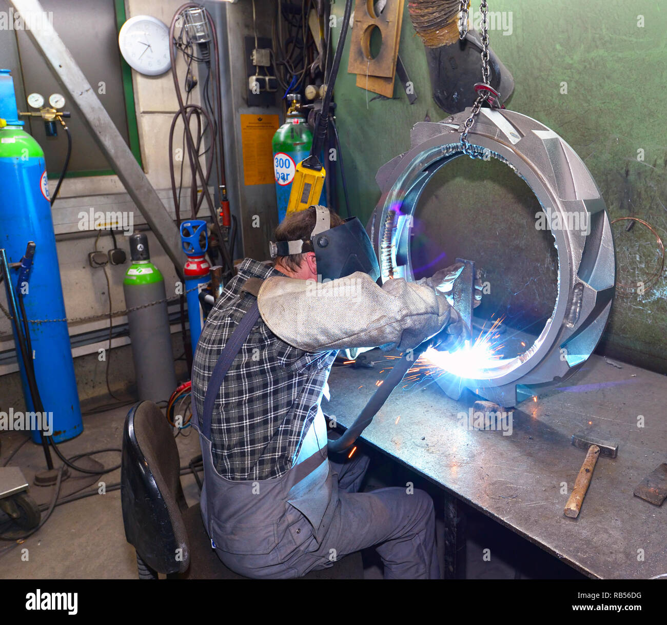 welder at a workplace in metal construction working on a workpiece made ...