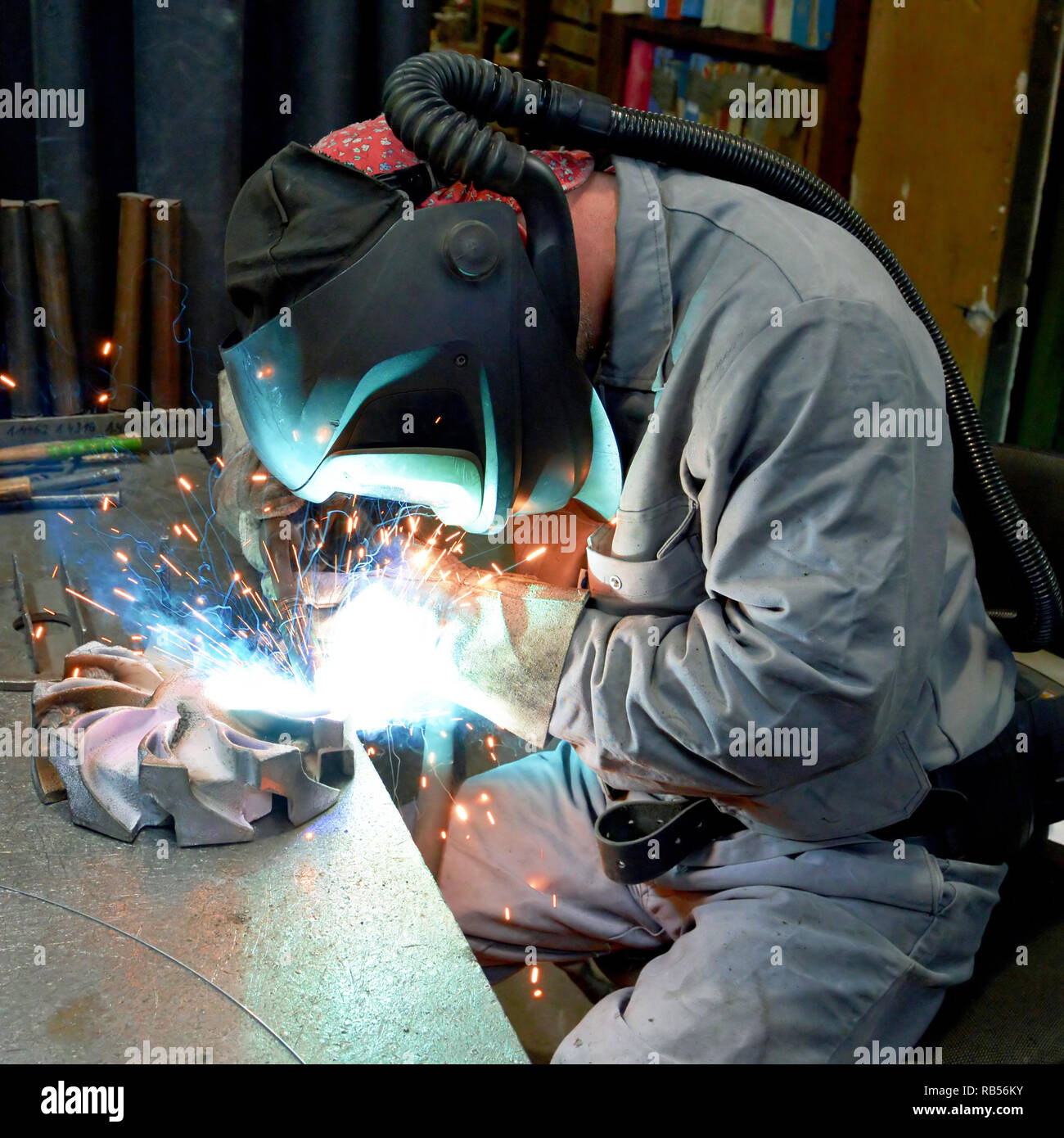 welder at a workplace in metal construction working on a workpiece made ...