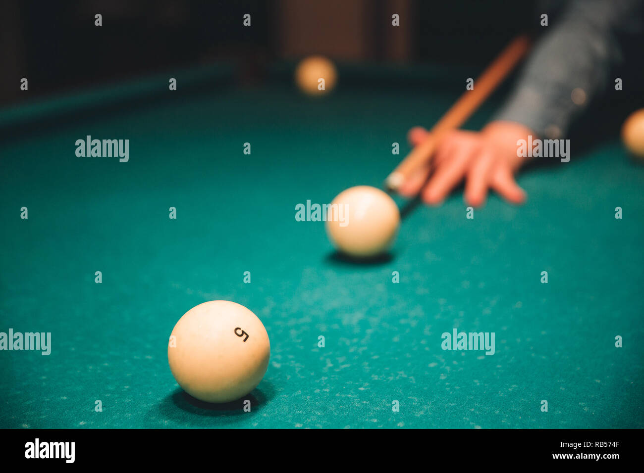 Picture of man's hand holding billiard cue and aiming to breal ball. he ...