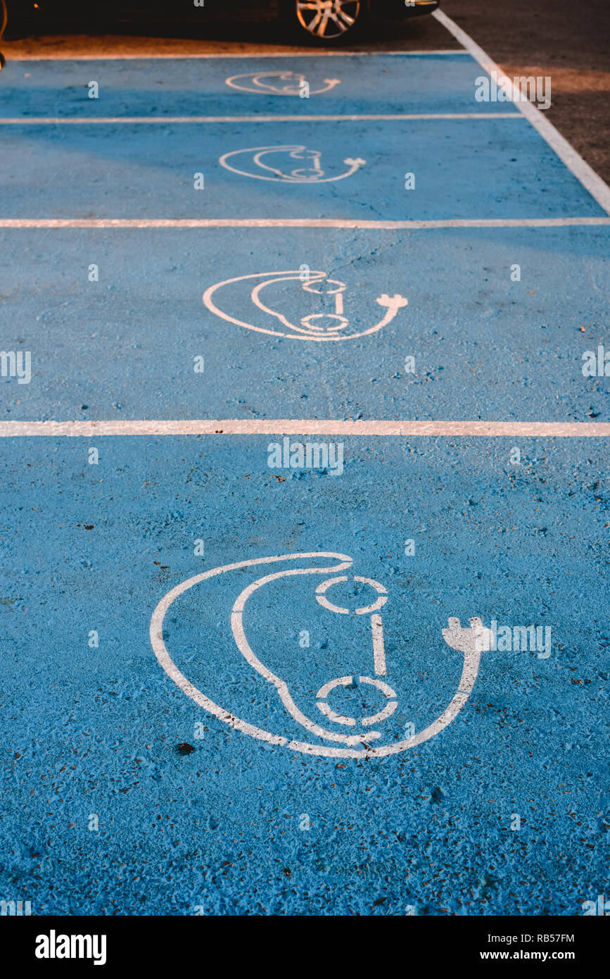 Electric cars. Sign painted on the floor of a parking lot for electric ...