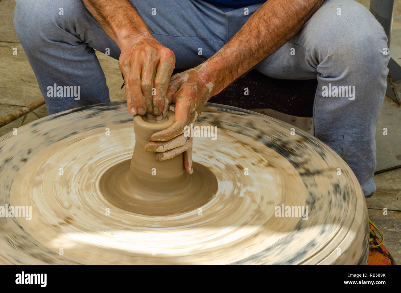 Closeup of the hands of the artist creating a clay pot, the traditional ...