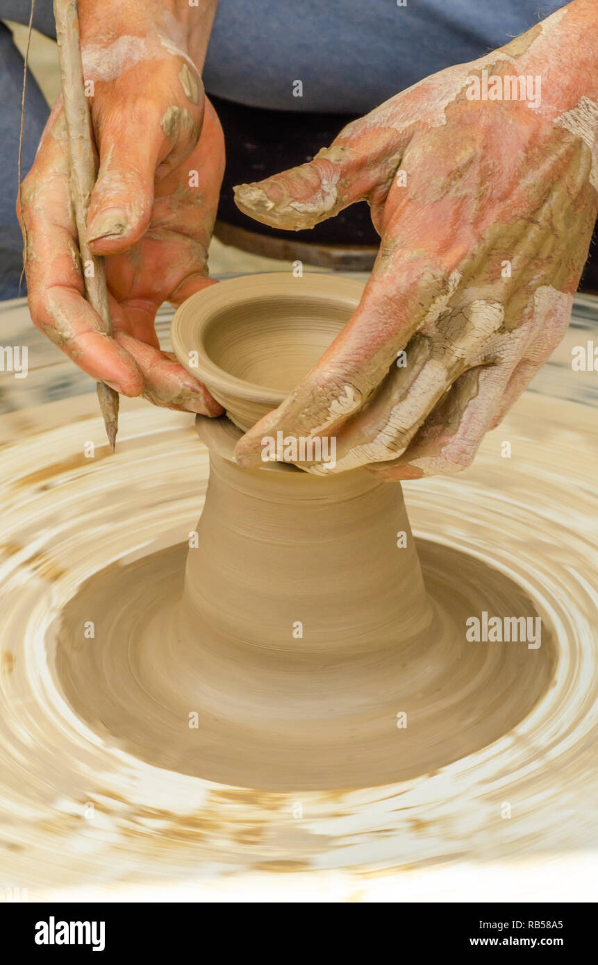 Closeup of the hands of the artist creating a clay pot, the traditional ...