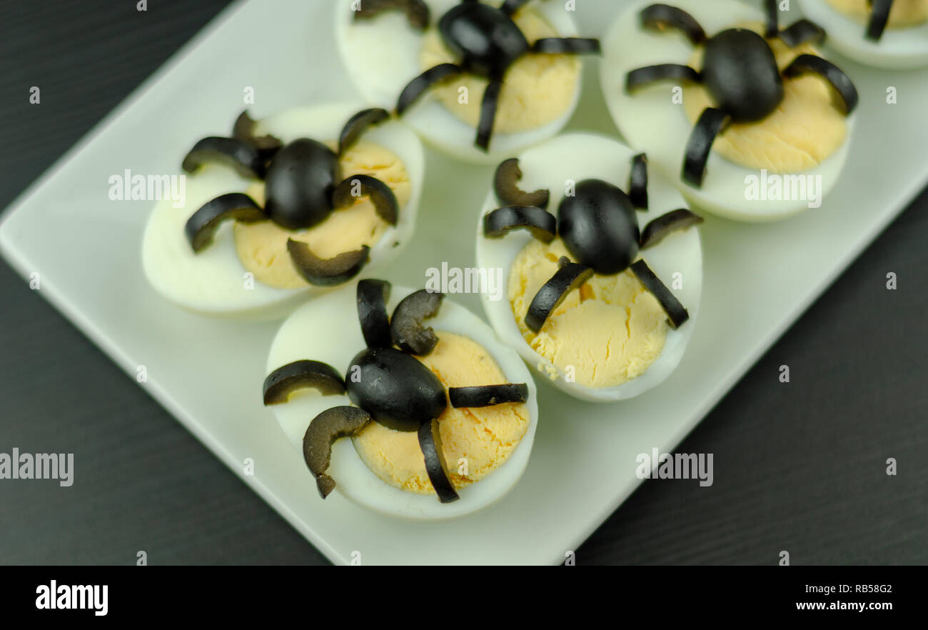 funny snack with olive spiders on egg halves for halloween party ...