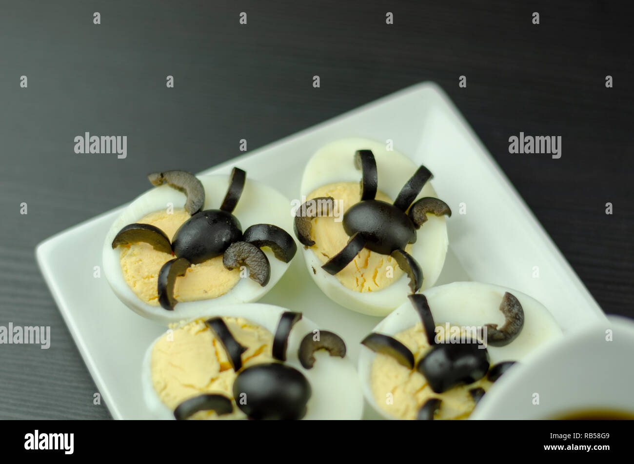 funny snack with olive spiders on egg halves for halloween party ...