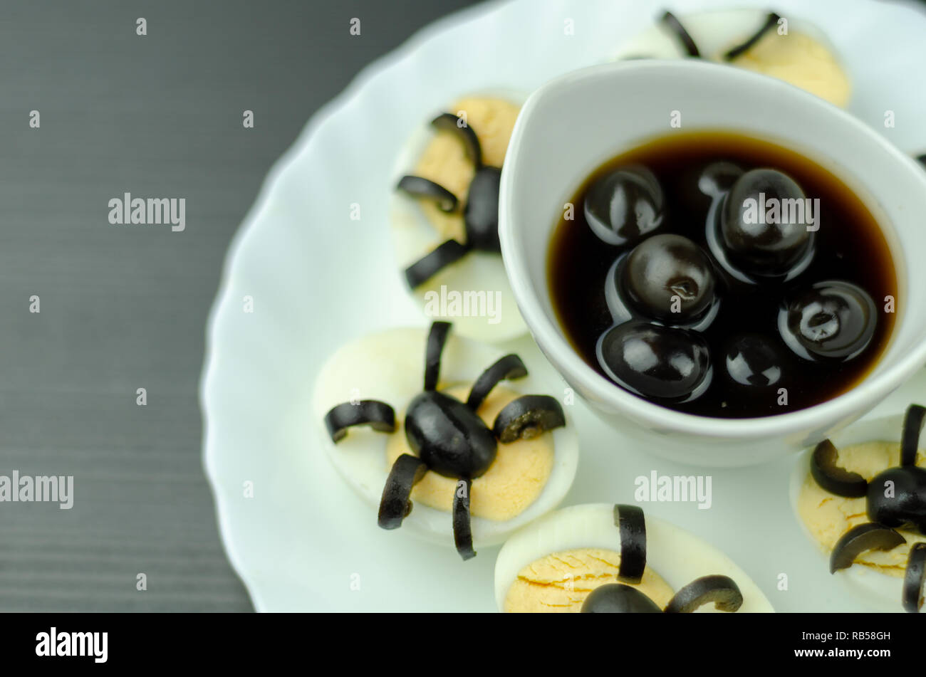 funny snack with olive spiders on egg halves for halloween party ...