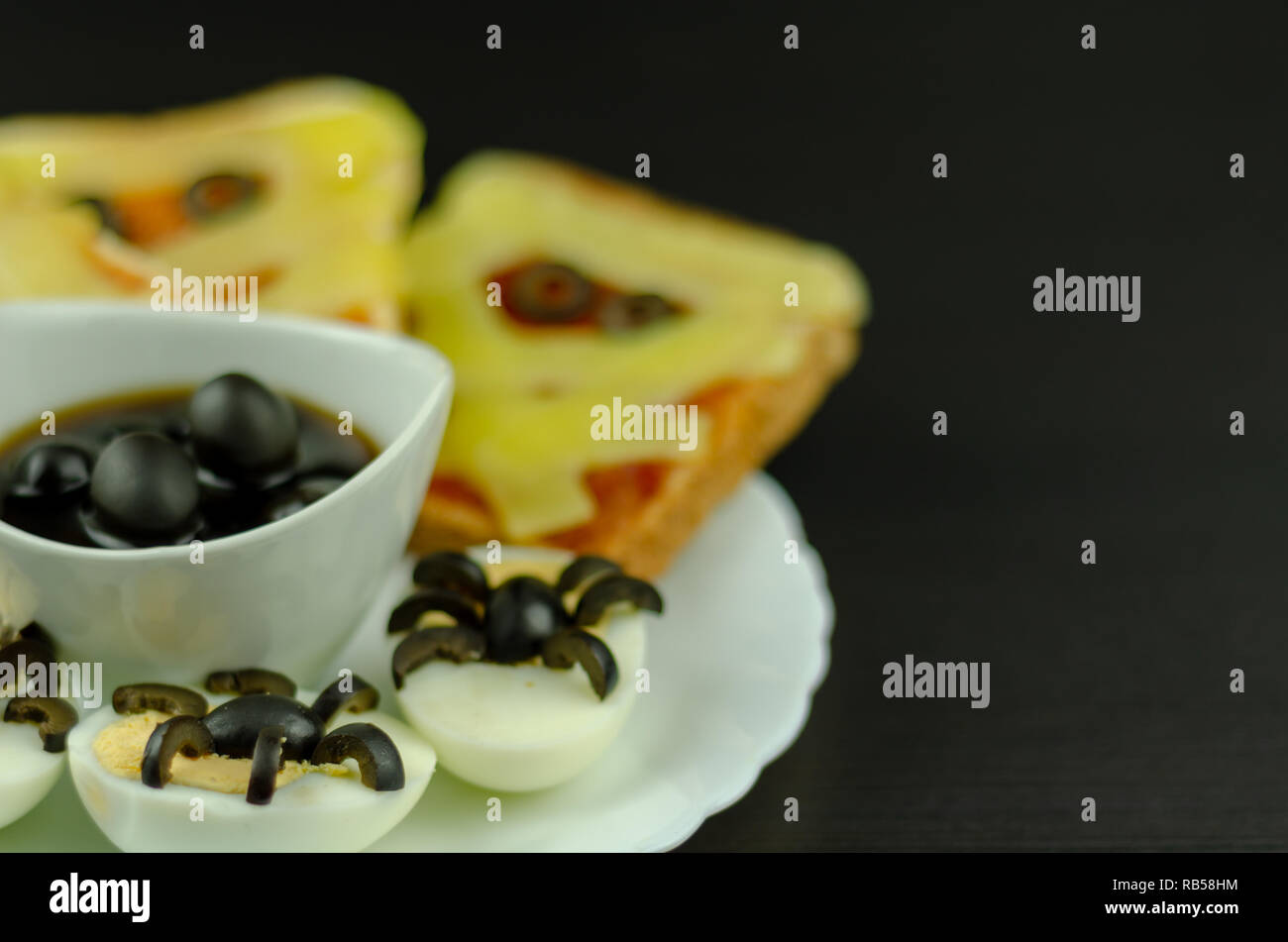 funny snack with olive spiders on egg halves for halloween party ...
