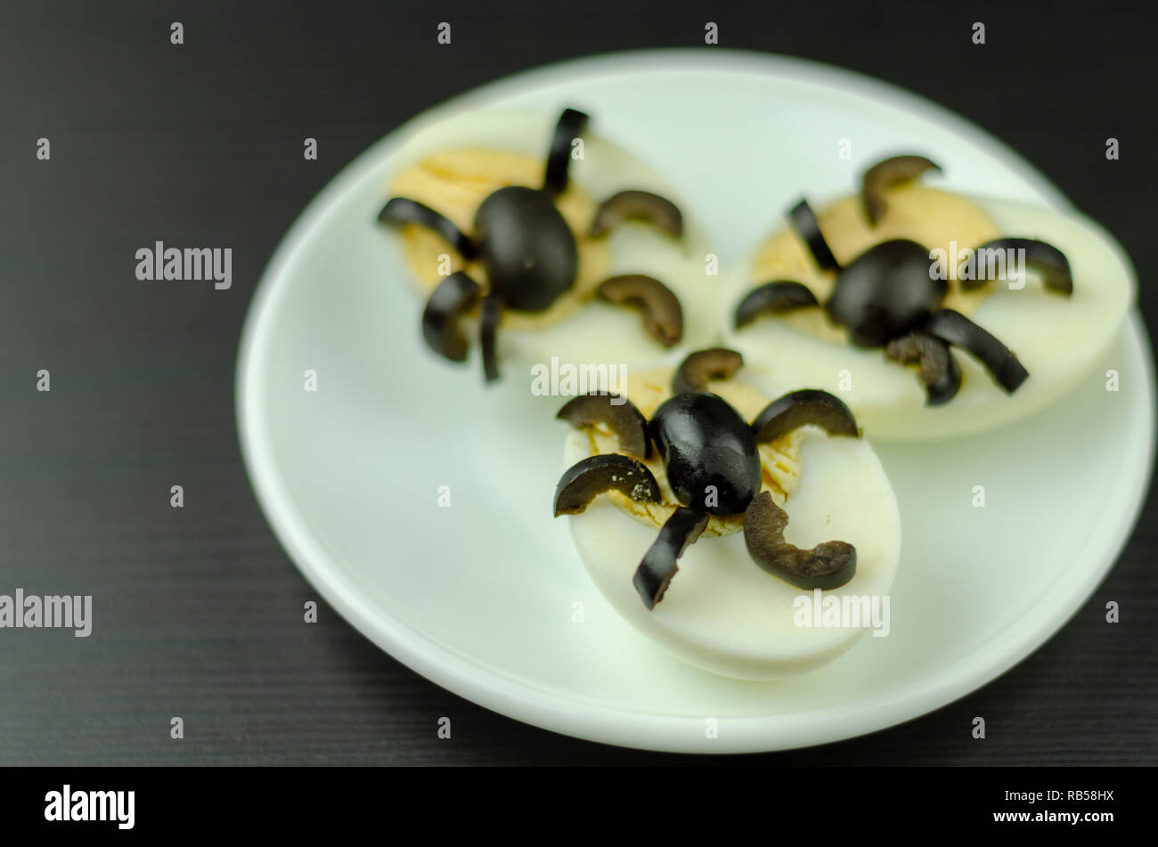 funny snack with olive spiders on egg halves for halloween party ...