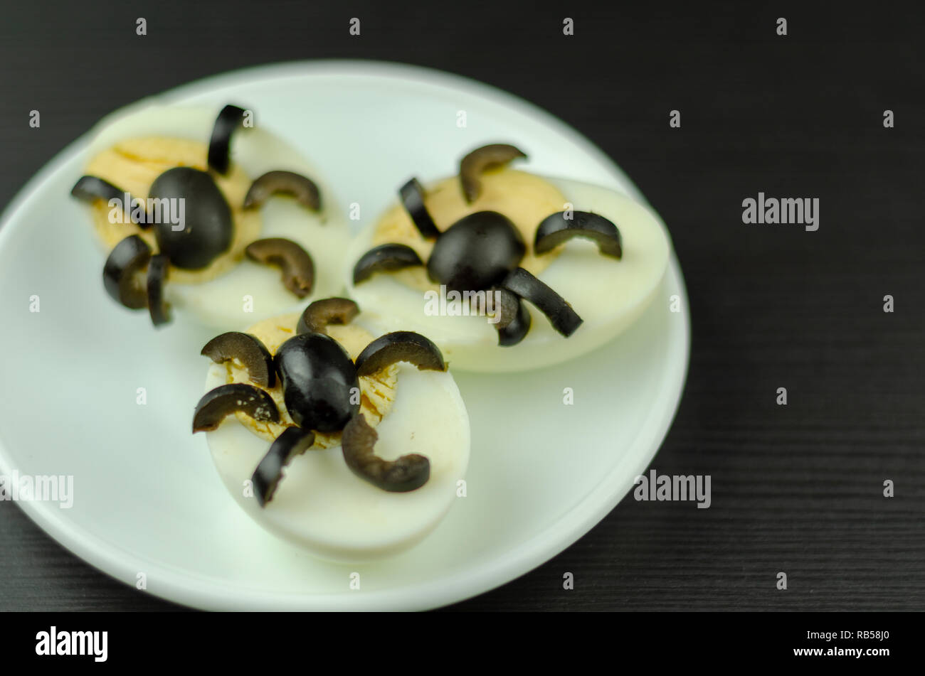 funny snack with olive spiders on egg halves for halloween party ...