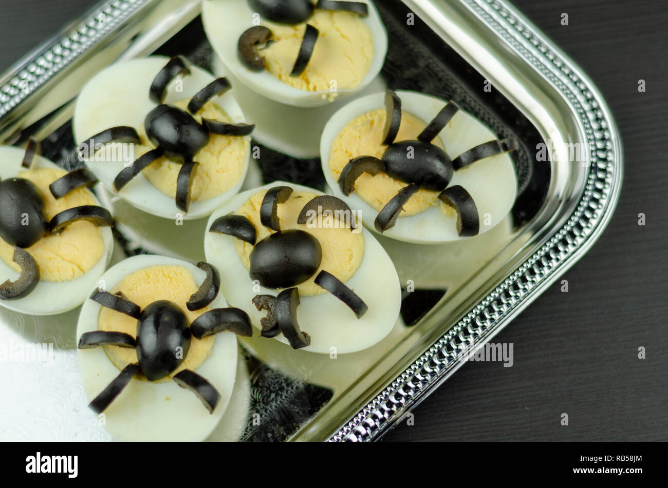 funny snack with olive spiders on egg halves for halloween party ...