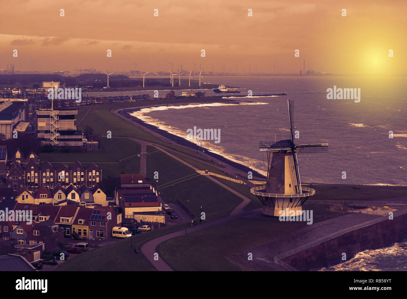 beautiful sunset at the windmill of Vlissingen, city skyline of a ...