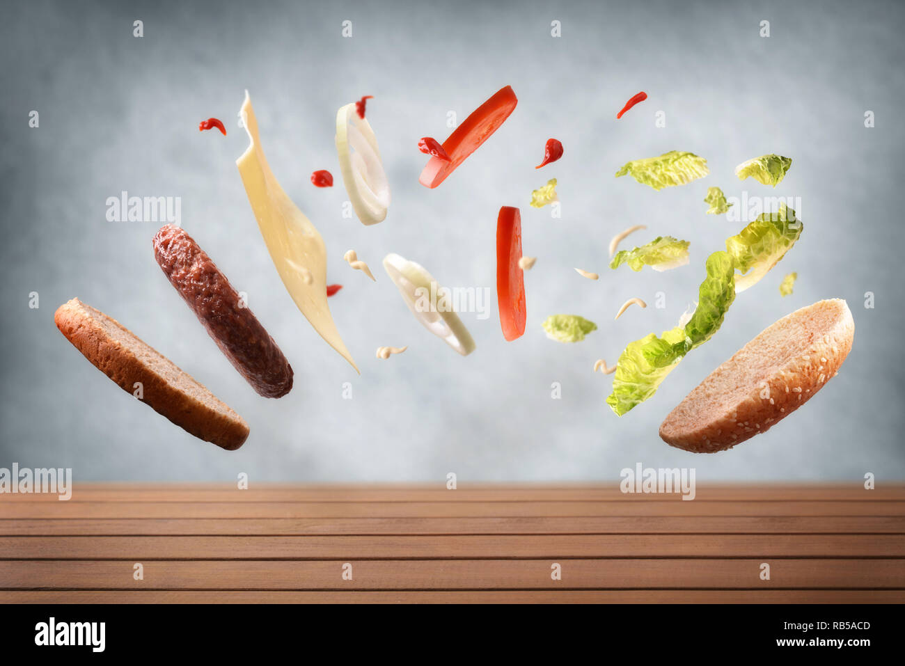 Classic beef burger floating on wood table and gray background. Front ...