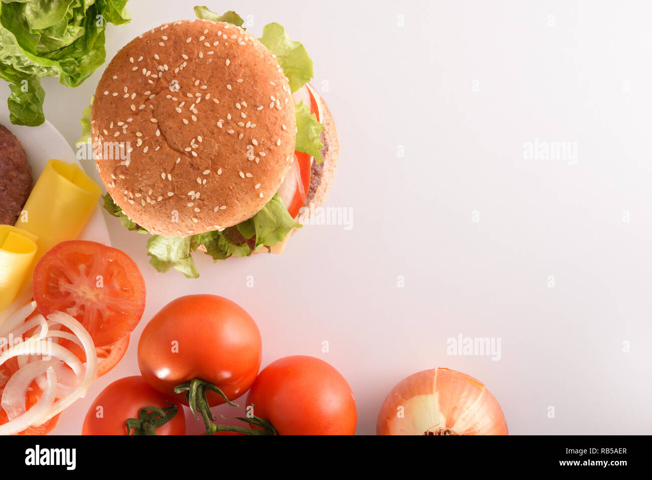 Homemade beef burger with ingredients on white table. Top view ...
