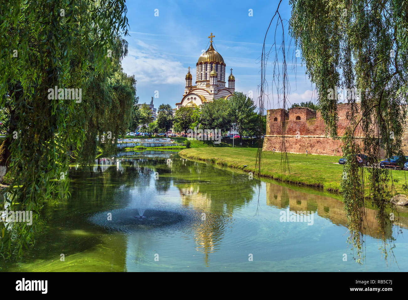 Nice scenario with a tall church and a lake with trees around in ...
