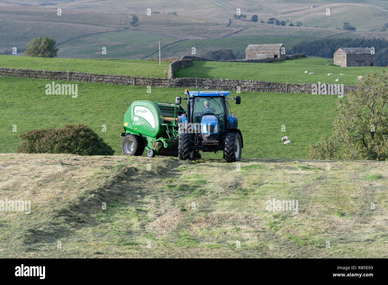 Making big bales of silage n an upland meadow with a New Holland TS135 ...