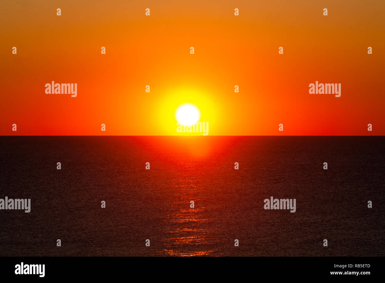 Golden sunset centered over a calm sea in Newquay, Cornwall, UK Stock ...
