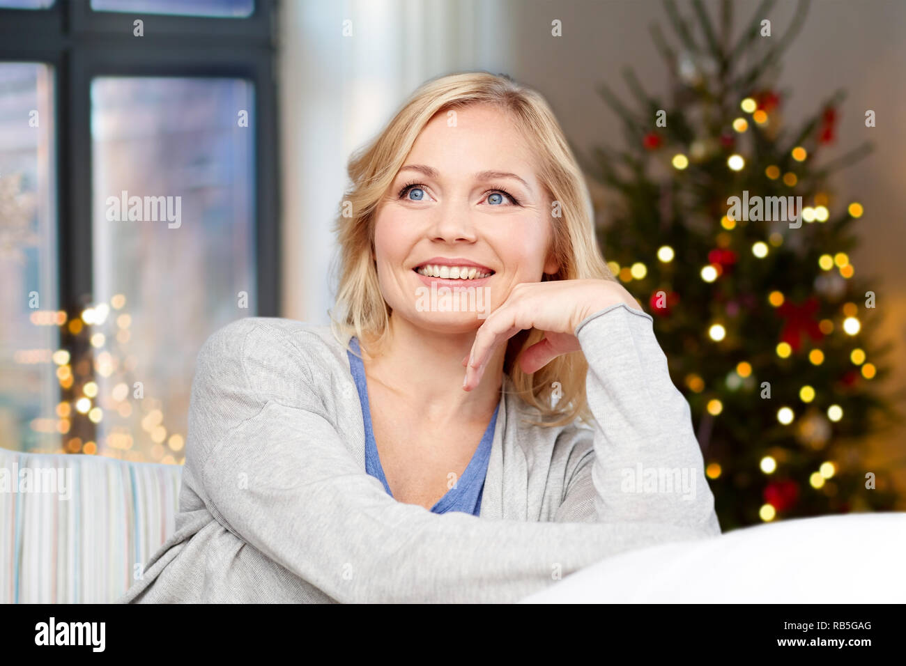 middle aged woman over christmas tree at home Stock Photo - Alamy