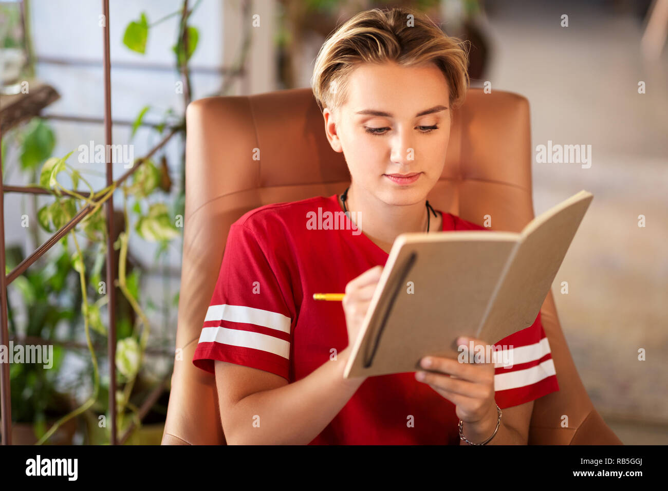 teenage girl writing to notebook at cafe Stock Photo - Alamy