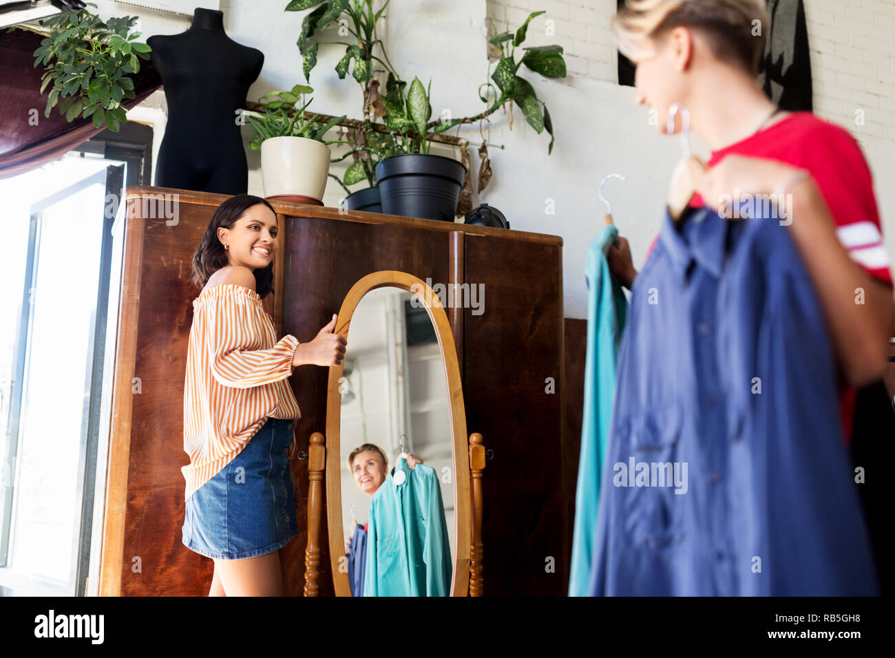 women choosing clothes at vintage clothing store Stock Photo - Alamy