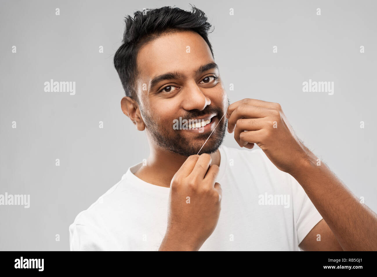 indian man with dental floss cleaning teeth Stock Photo - Alamy