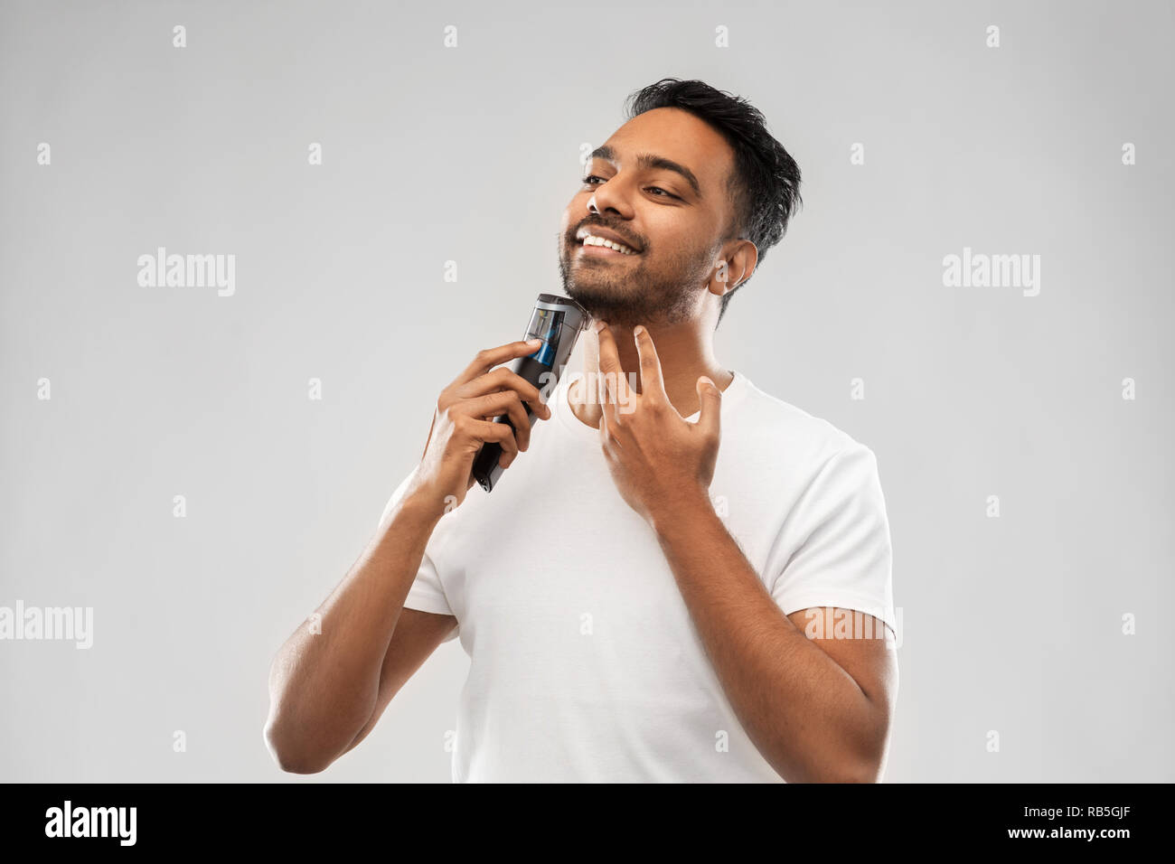 smiling indian man shaving beard with trimmer Stock Photo - Alamy