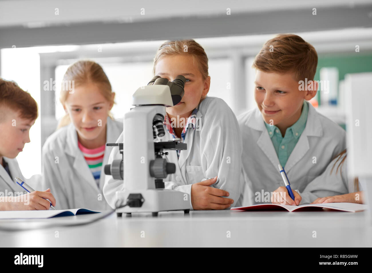 kids or students with microscope biology at school Stock Photo - Alamy